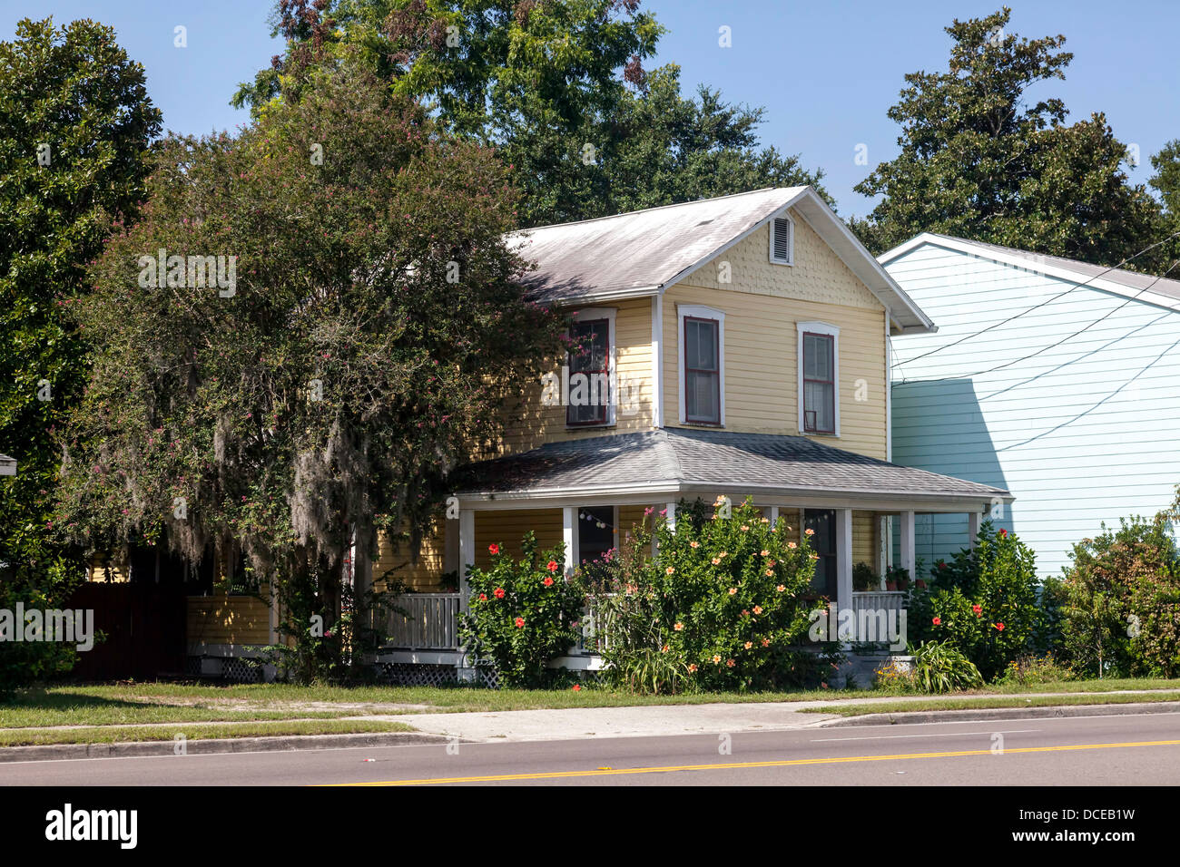 Yellow, 2-story clapboard house with white trim, porch veranda and ...