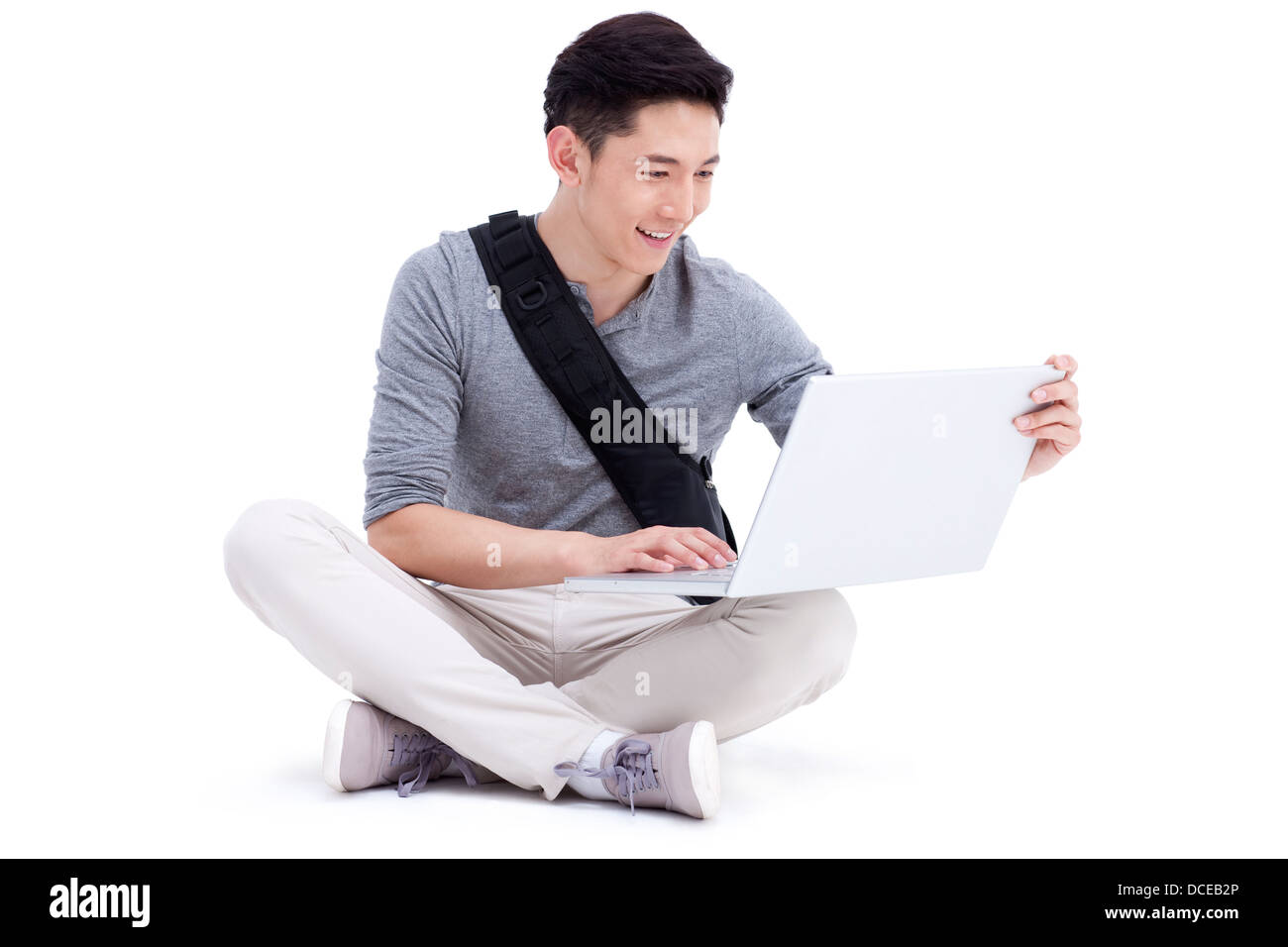 Happy male college student using laptop Stock Photo - Alamy