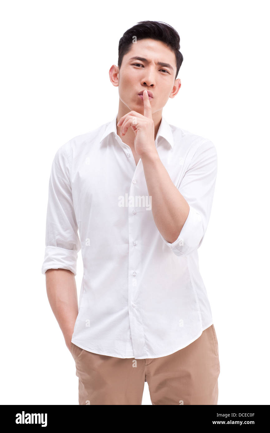 Young man with finger on lips Stock Photo - Alamy