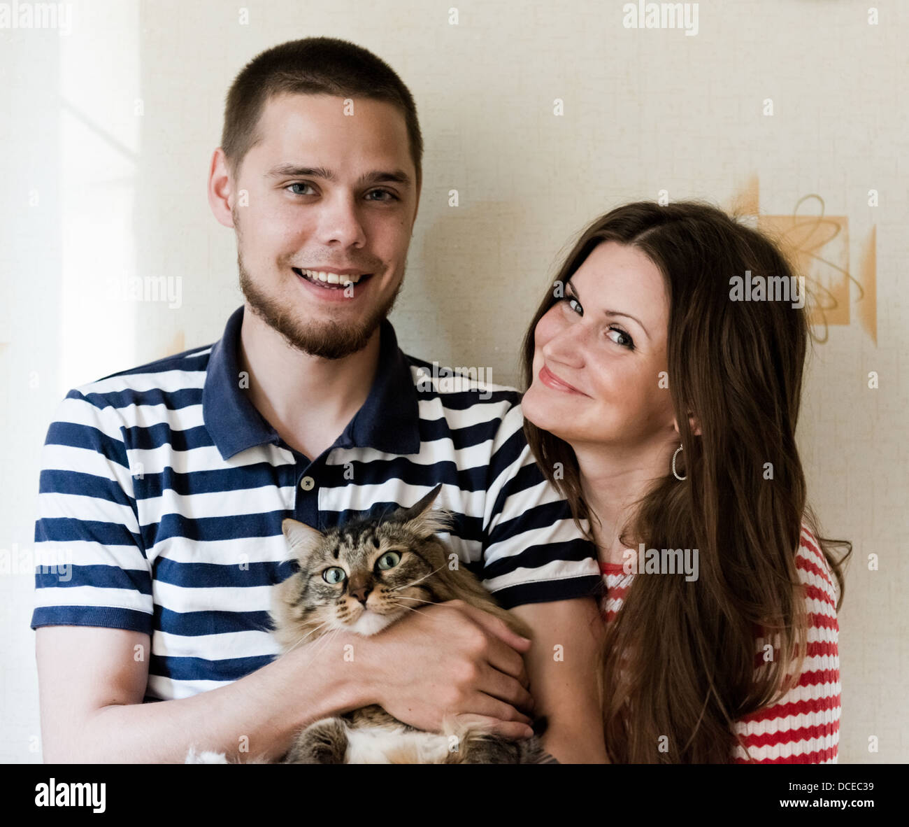 happy young couple at home with their cat Stock Photo - Alamy