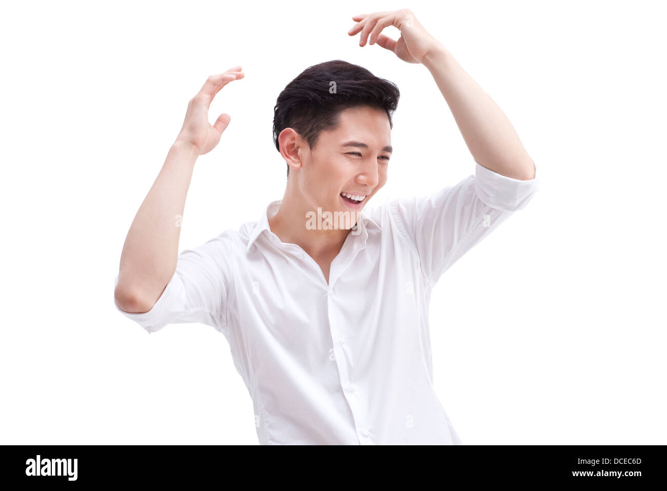 Cheerful young man raising hands Stock Photo - Alamy