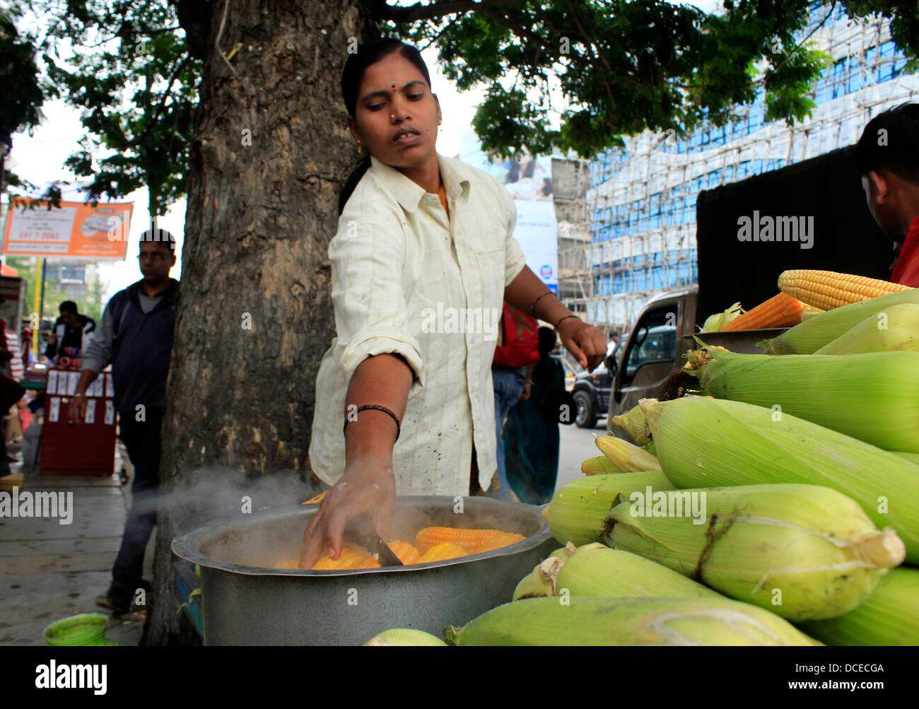 Indian woman roasting corn at a roadside shop in bangalore Stock Photo ...