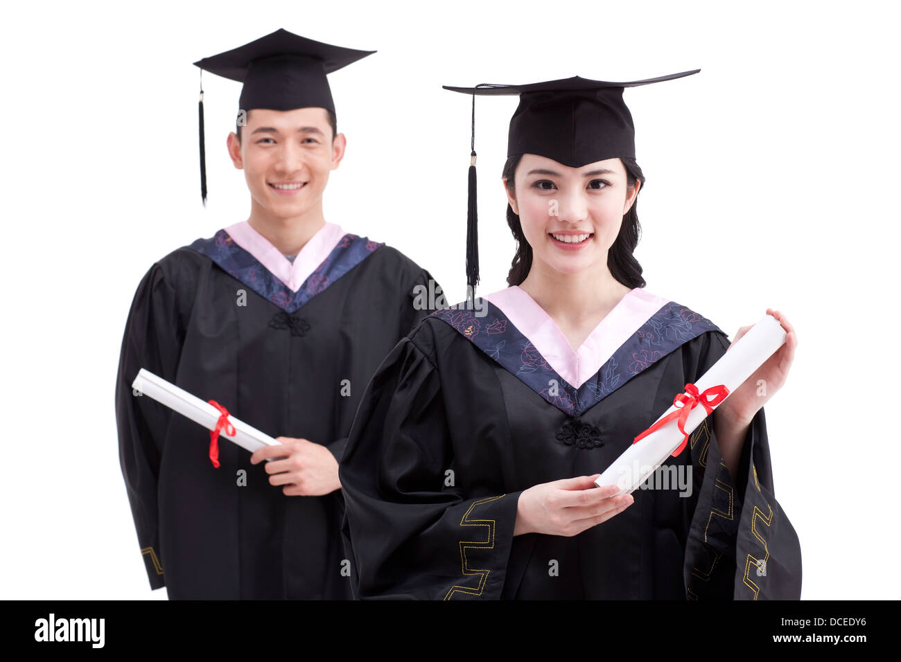 Happy college graduates in graduation gowns Stock Photo - Alamy