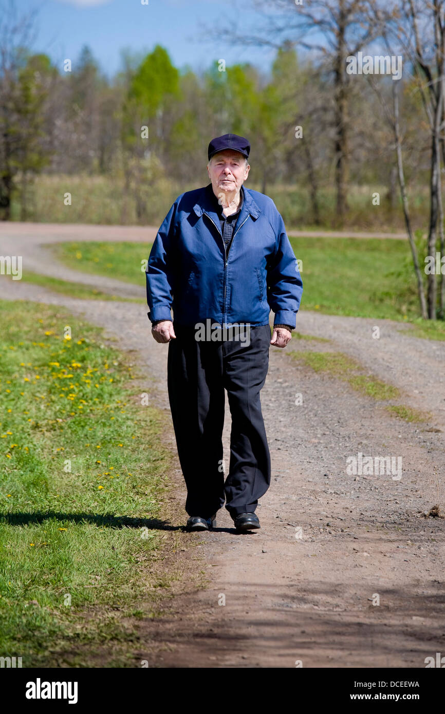 Elderly man walking on country road Stock Photo - Alamy