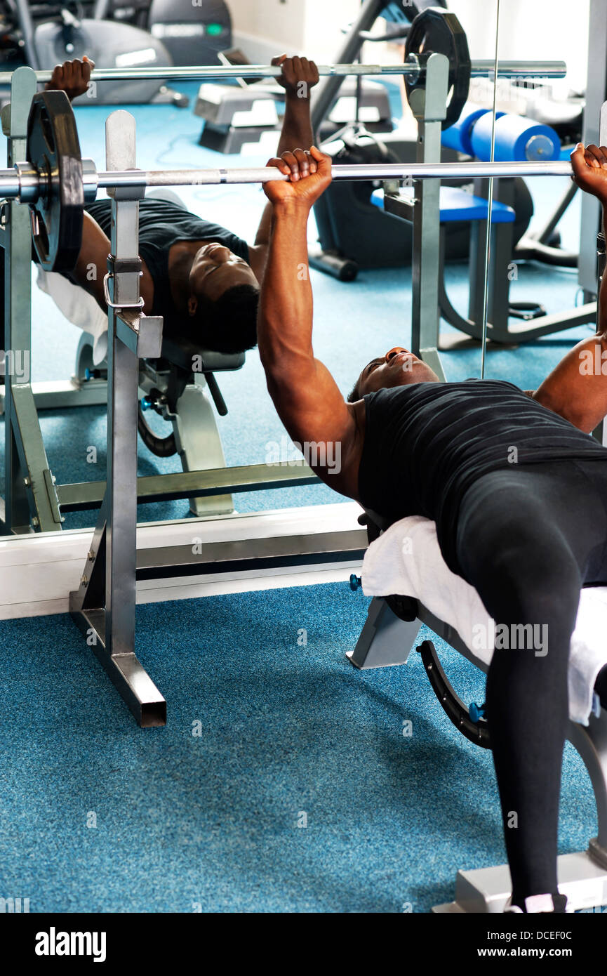 Young muscular man lifting the barbell bench press Stock Photo - Alamy