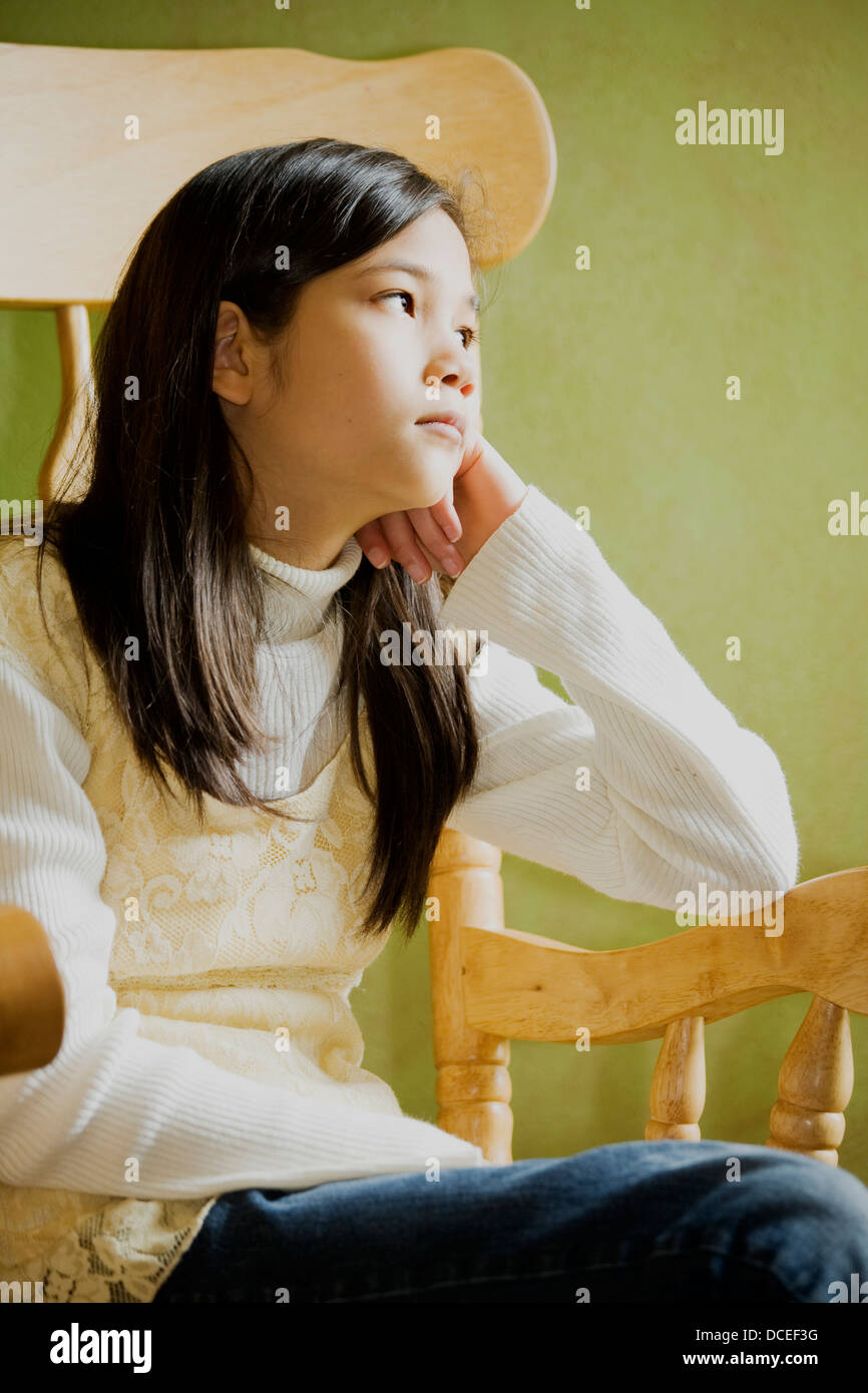 Girl in rocking chair looking out window, thoughtful look Stock Photo ...