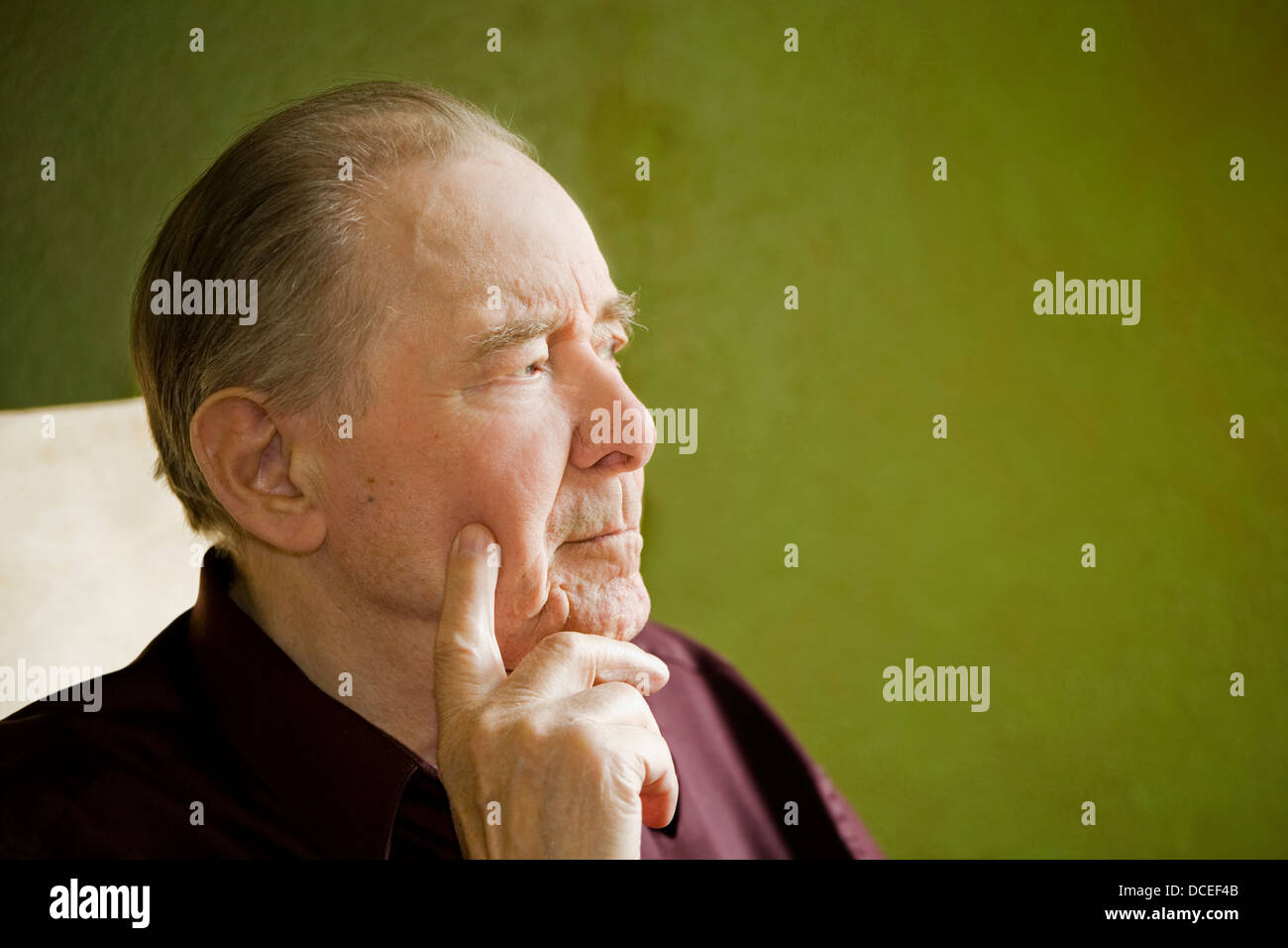 Elderly man in rocking chair looking out sunny window Stock Photo - Alamy