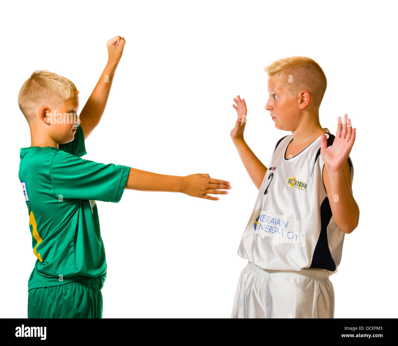 Young boy refereeing his brother on basketball game, studio shot, white ...
