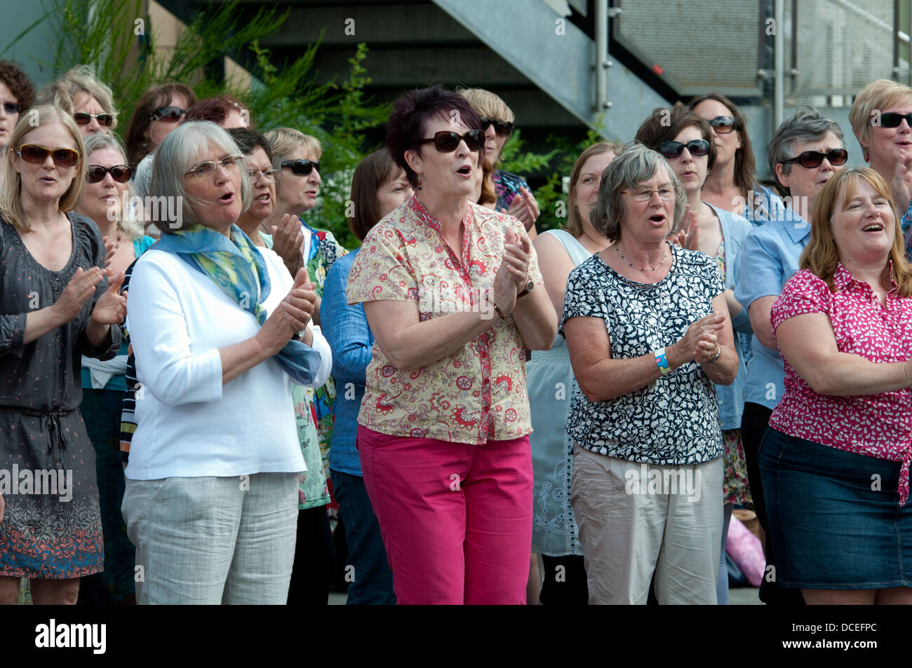 A community choir singing and clapping hands at Warwick Folk Festival ...