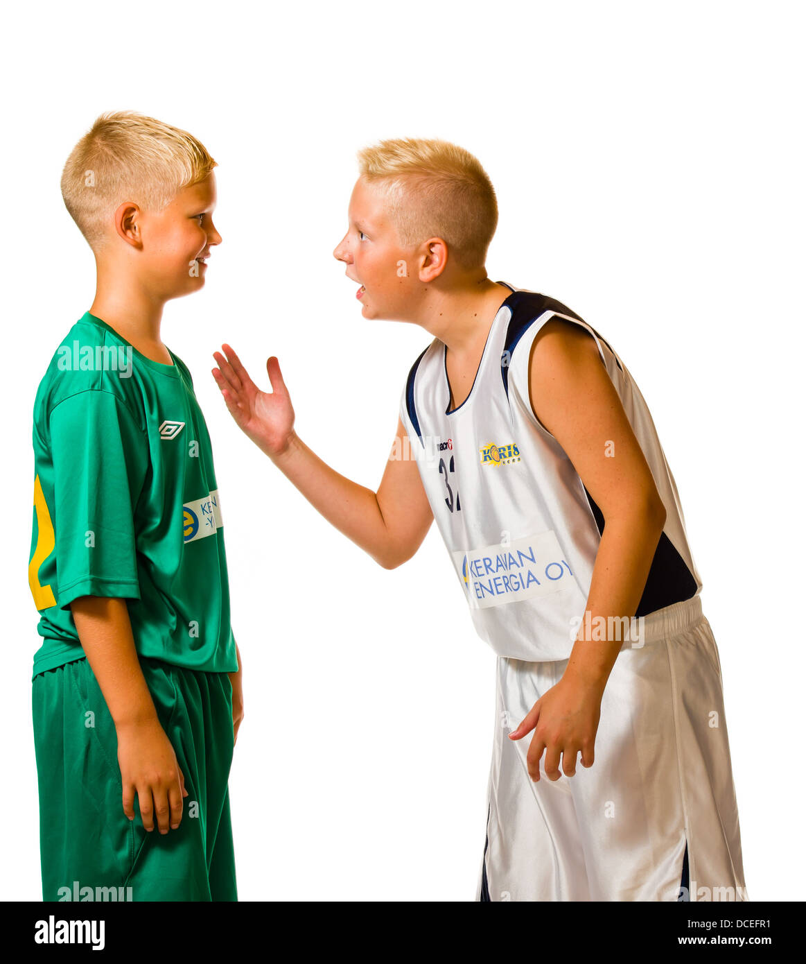 Young boy refereeing his brother on basketball game, studio shot, white ...