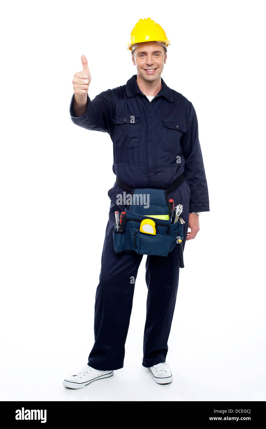 Young smiling industrial engineer showing thumbs up over white ...