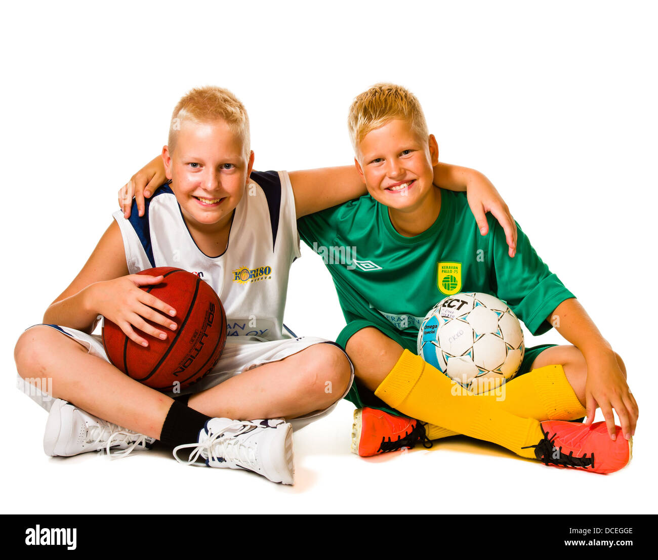 Brothers, young players sitting together on studio, white background ...