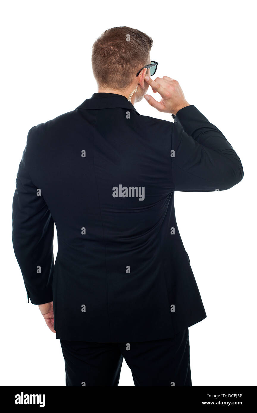 Bodyguard listening to vital information carefully while holding his ...