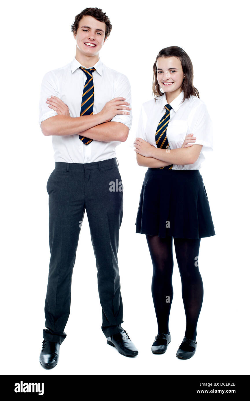 Full length portrait of teen students in uniform posing with arms ...