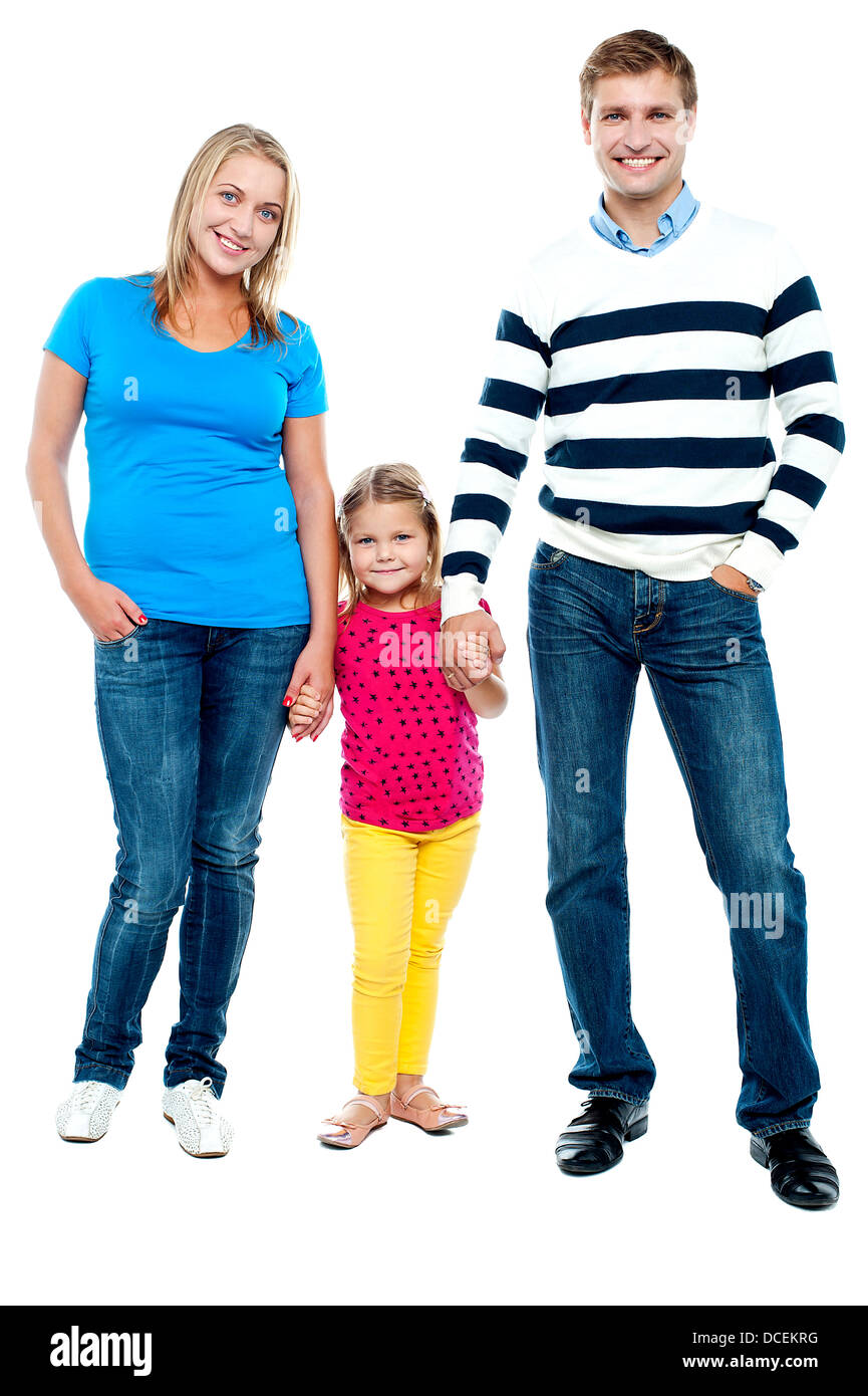 Sweet little kid standing in between her parents and holding their ...
