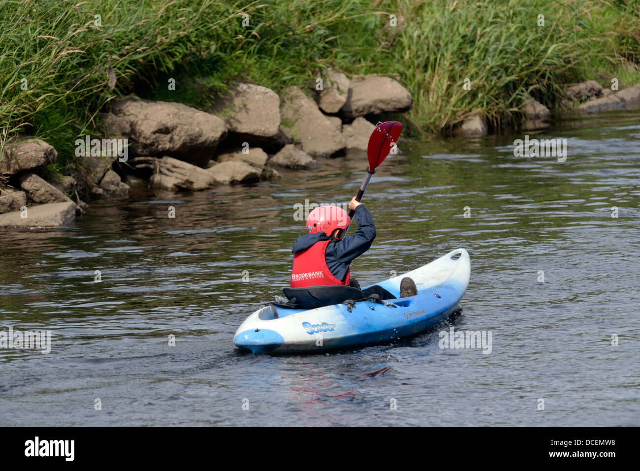 a young boy canoes on the river mersey, didsbury, manchester, england ...