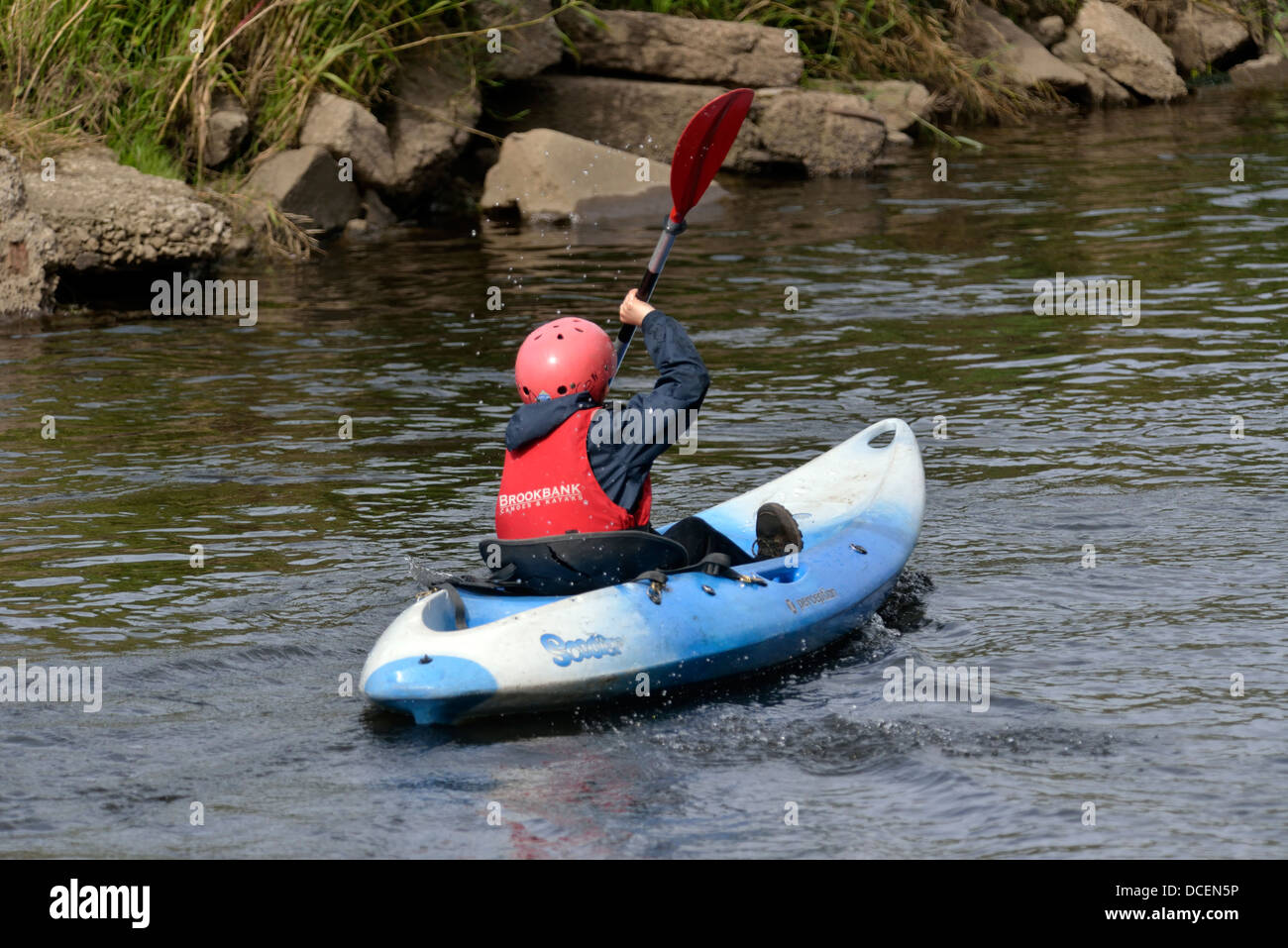 a young boy canoes on the river mersey, didsbury, manchester, england ...