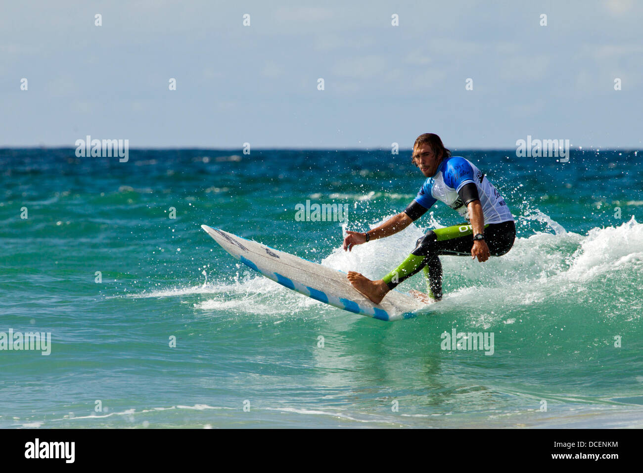 Adam Griffiths riding down a falling wave in the back of the longboard ...