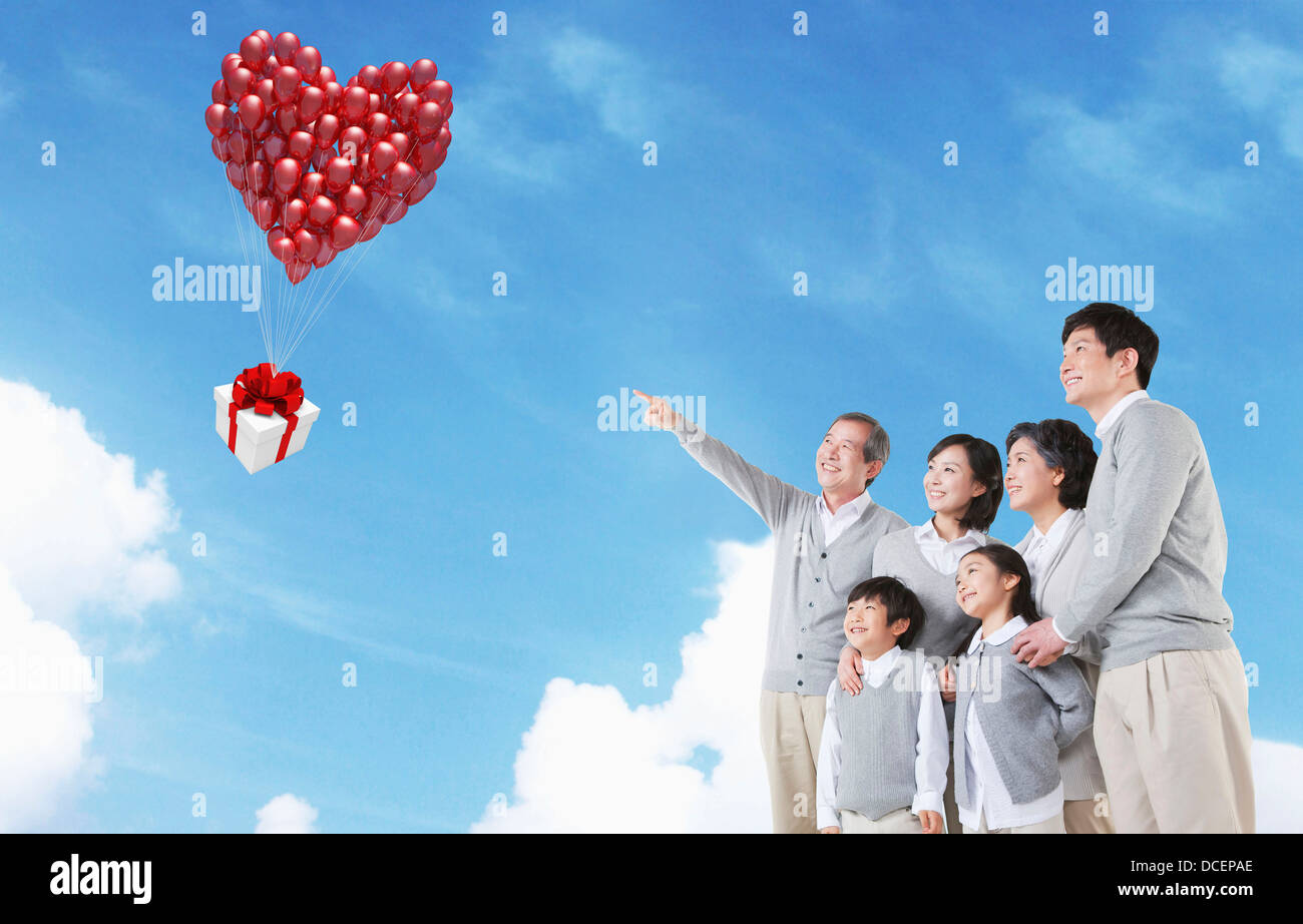 three generations looking at a present flying away Stock Photo - Alamy