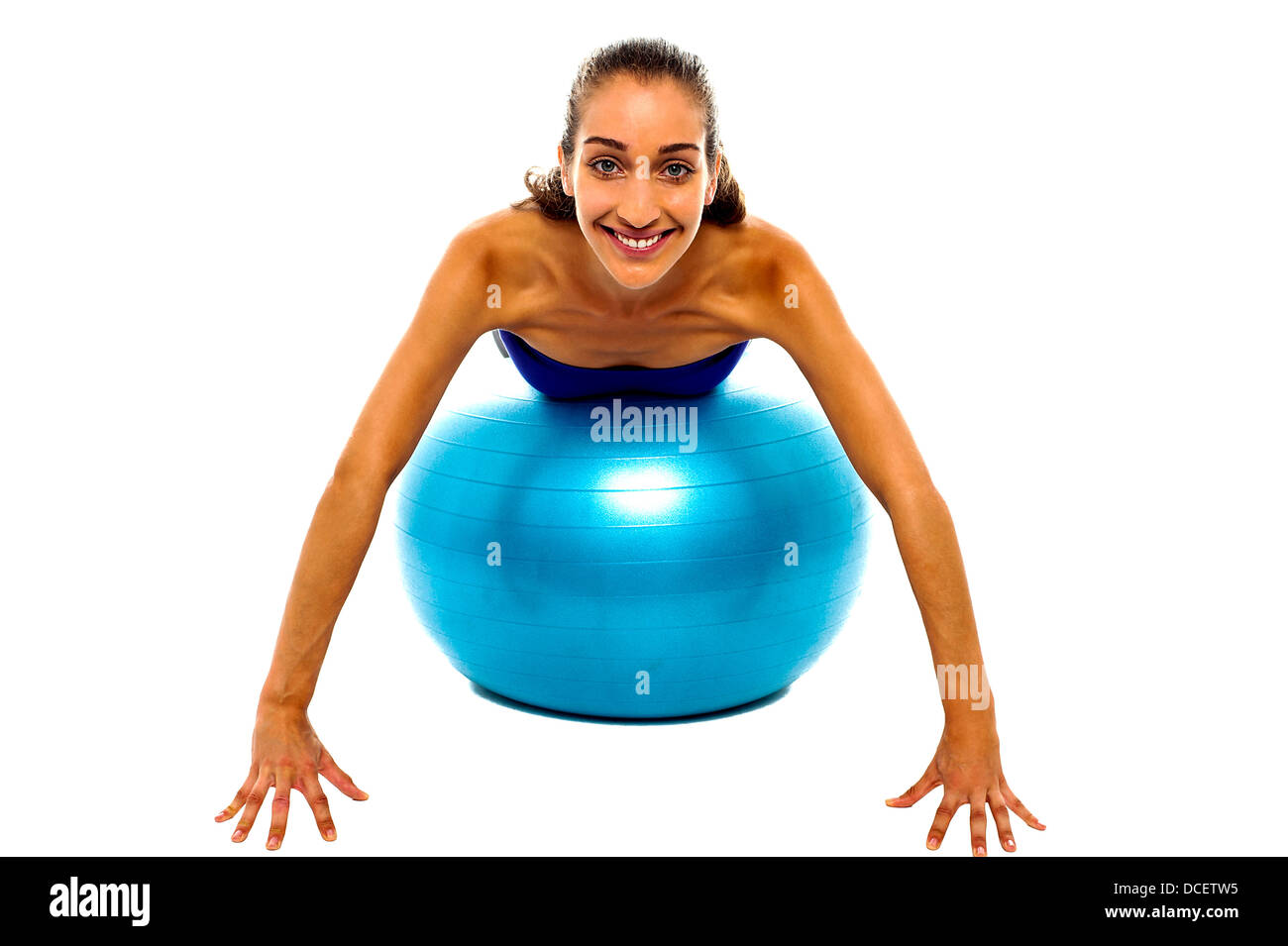 Young lady performing abdomen exercise by leaning over fitness ball ...