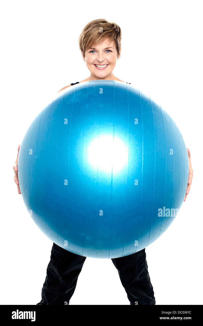 Charming woman holding big blue fitness ball in front of camera Stock ...
