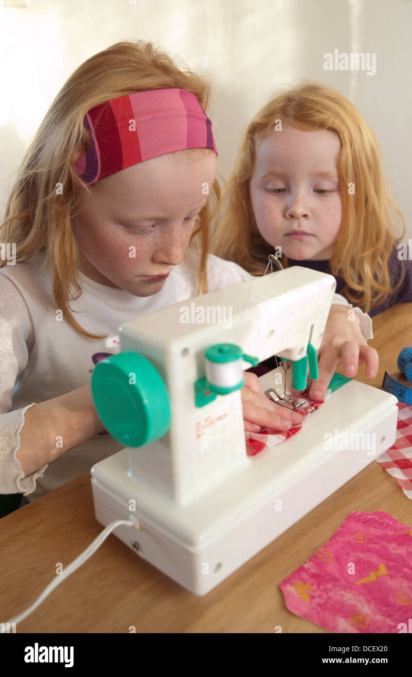 Little girls with a sewing-machine Stock Photo - Alamy
