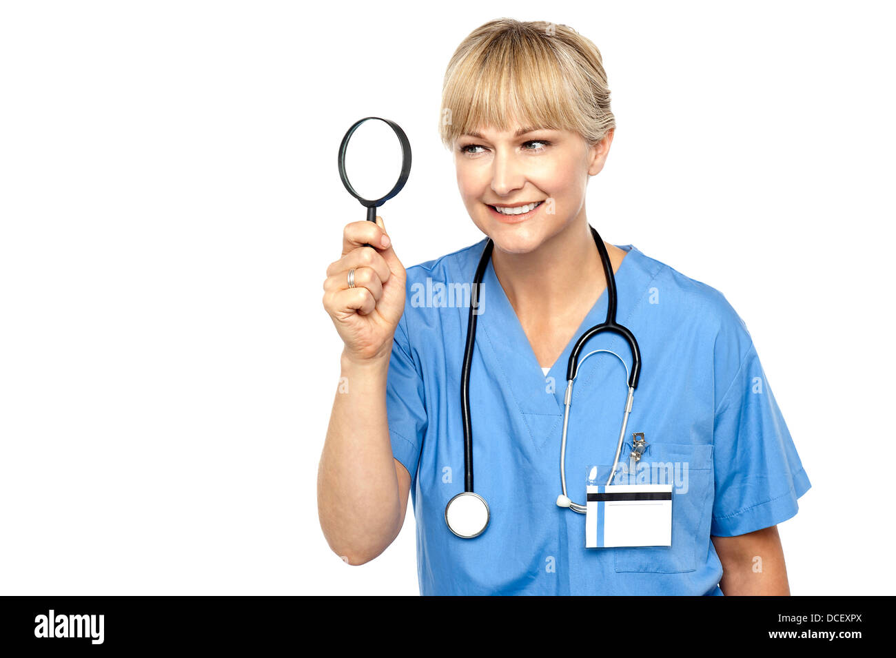 Pretty physician looking through magnifying glass, observing something ...