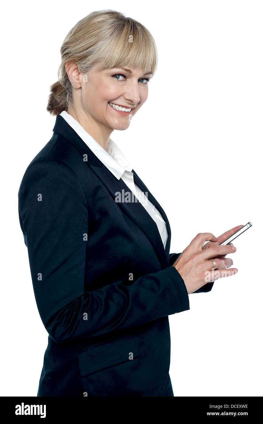 Female executive operating touch screen cellphone while smiling at ...