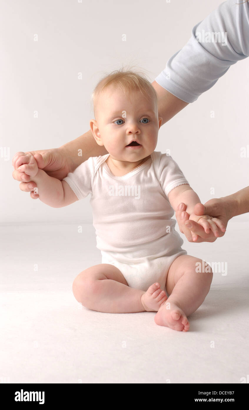 Baby girl sitting with some help Stock Photo - Alamy