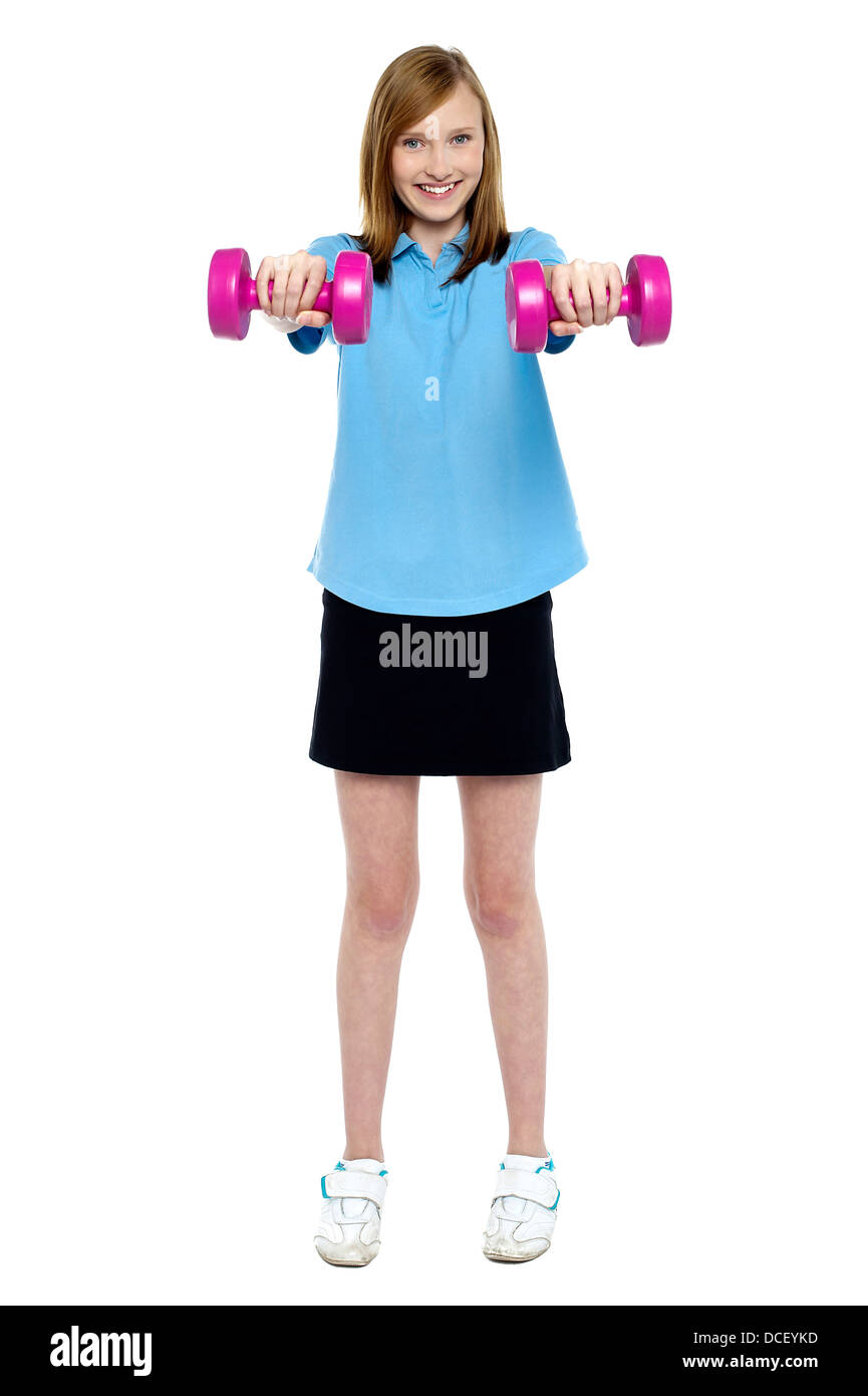 Slim girl striking a pose with dumbbells. Lifting weights. Full length ...