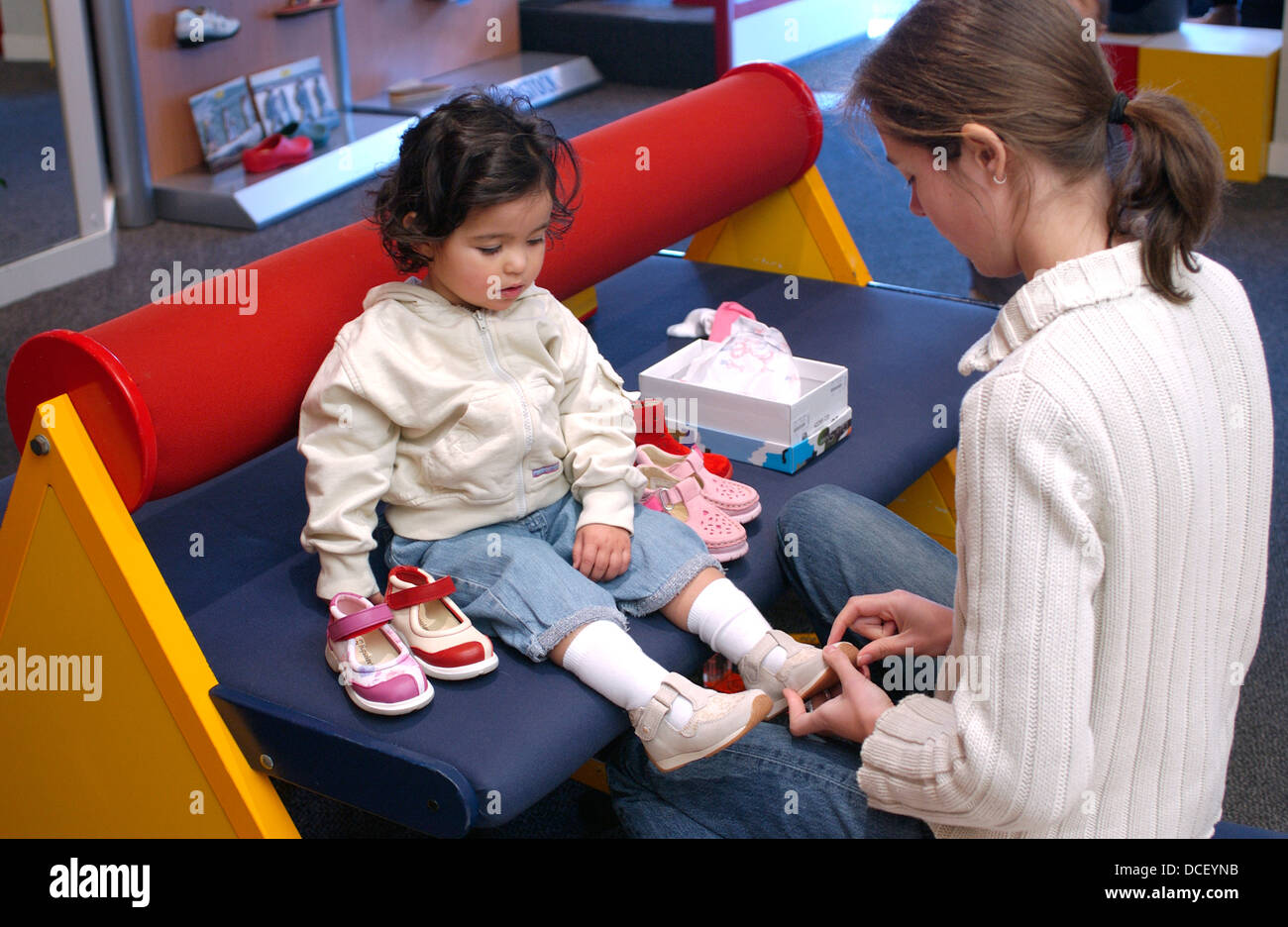 Little girl is buying new shoes in the shop Stock Photo - Alamy