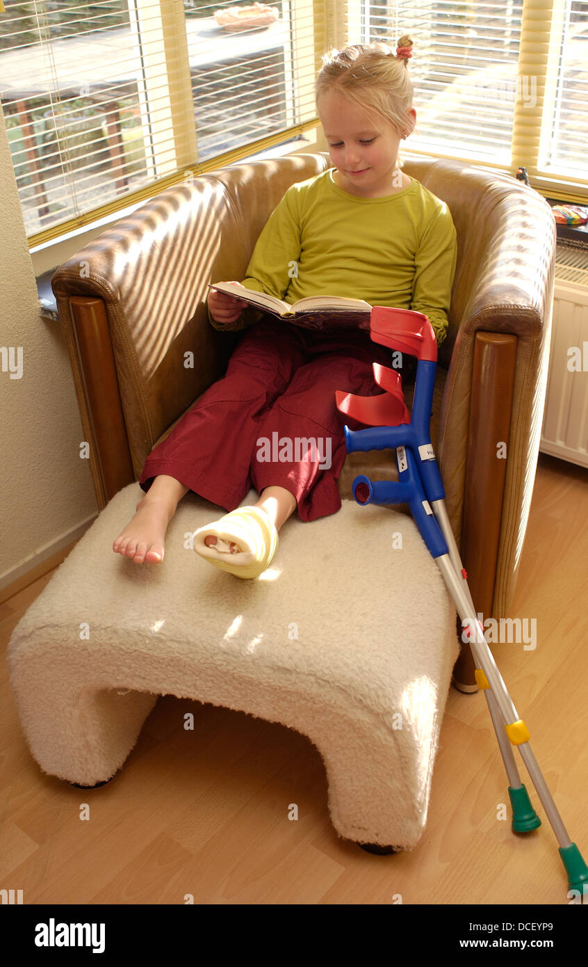 Girl with a broken leg reading a book Stock Photo - Alamy