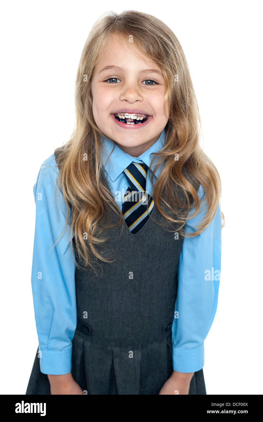 An active kid with a bright smile in school uniform expressing her ...