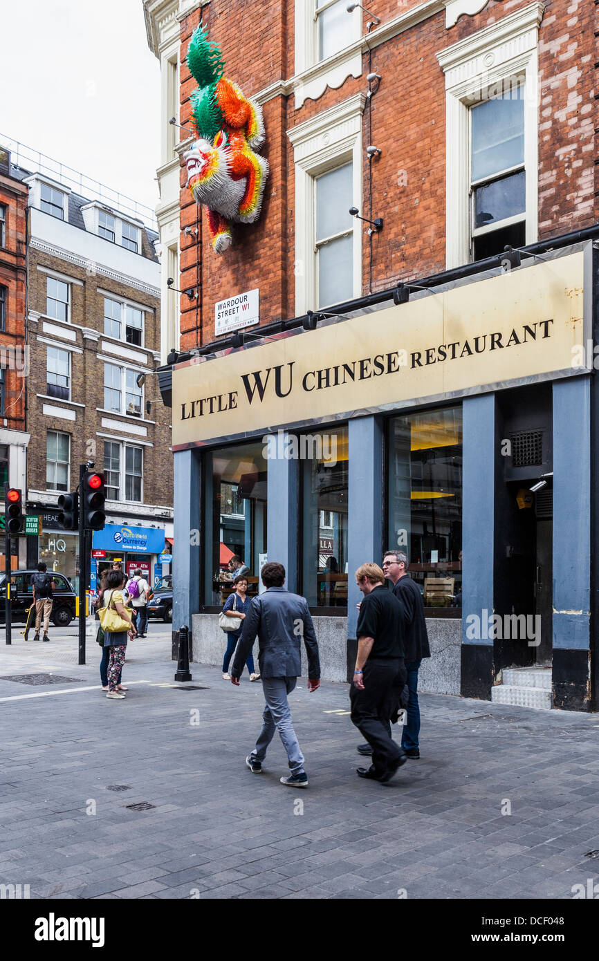 People walking past striking wall decoration above the Little Wu ...