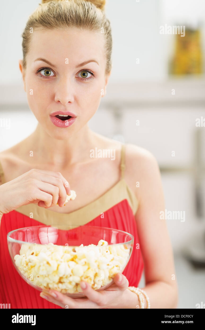 Portrait of young woman eating popcorn Stock Photo - Alamy