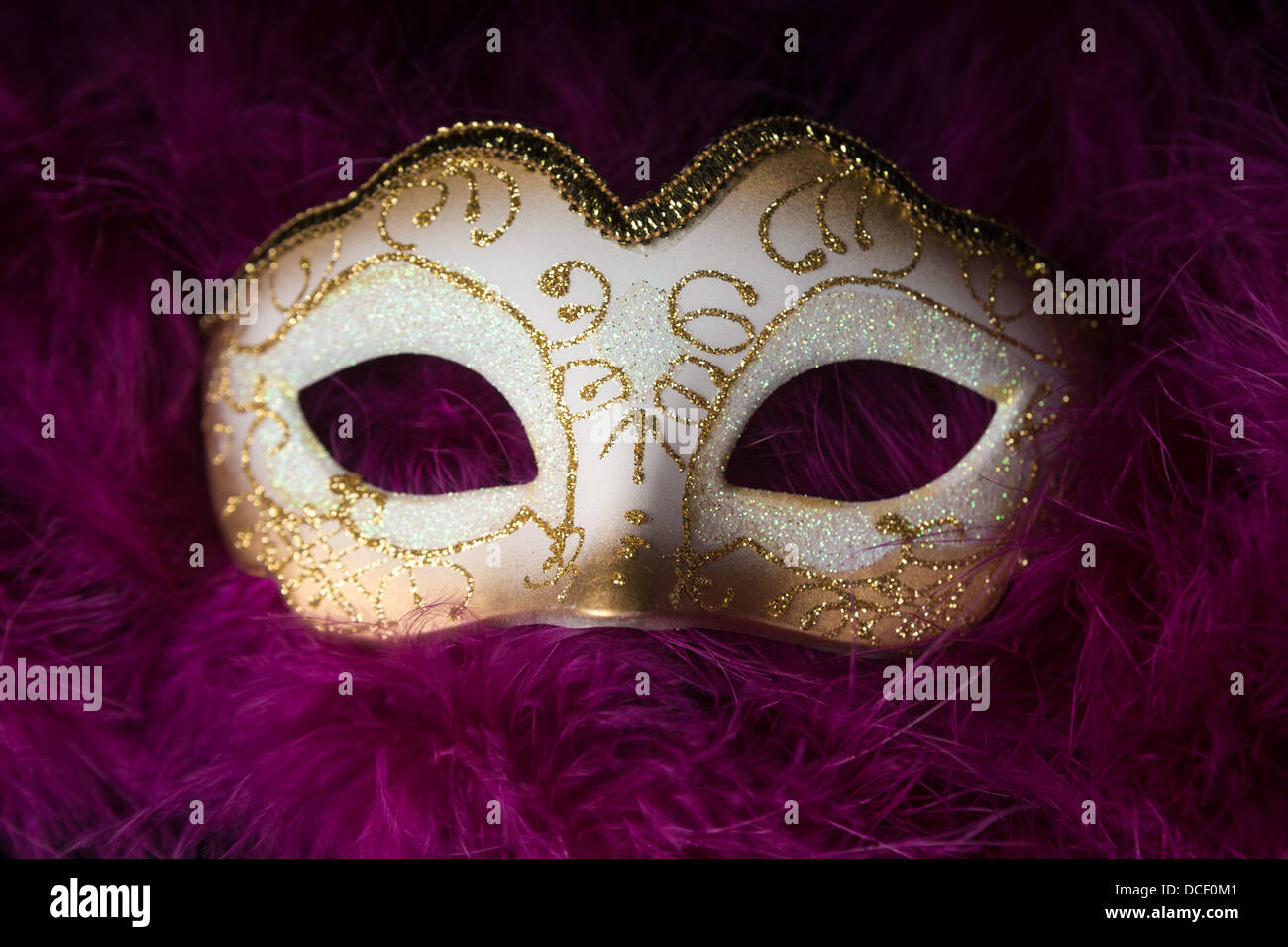 Mardi Gras mask on feather boa background Stock Photo - Alamy