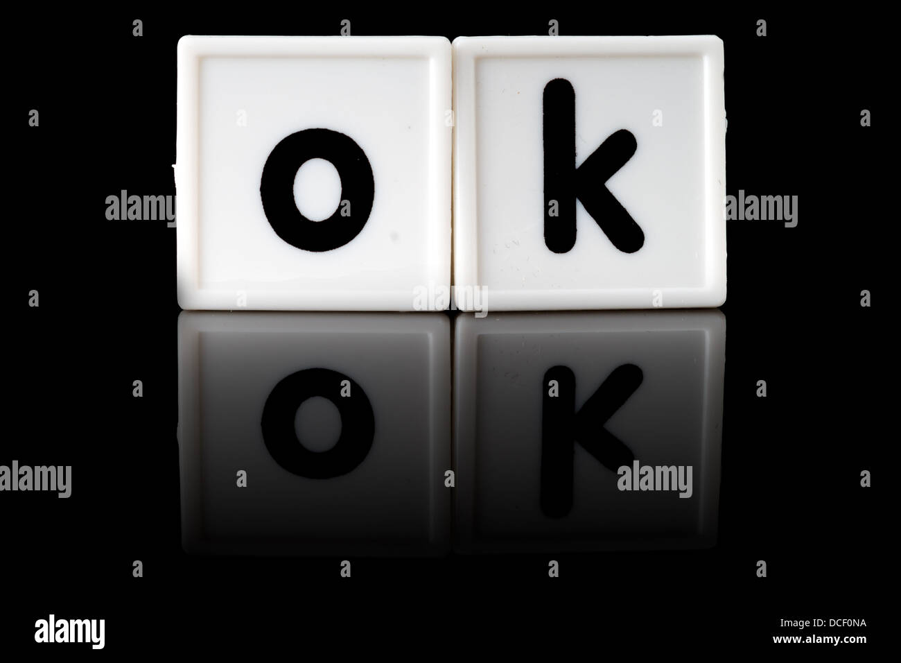 OK spelled in game letters reflected on isolated black background Stock ...