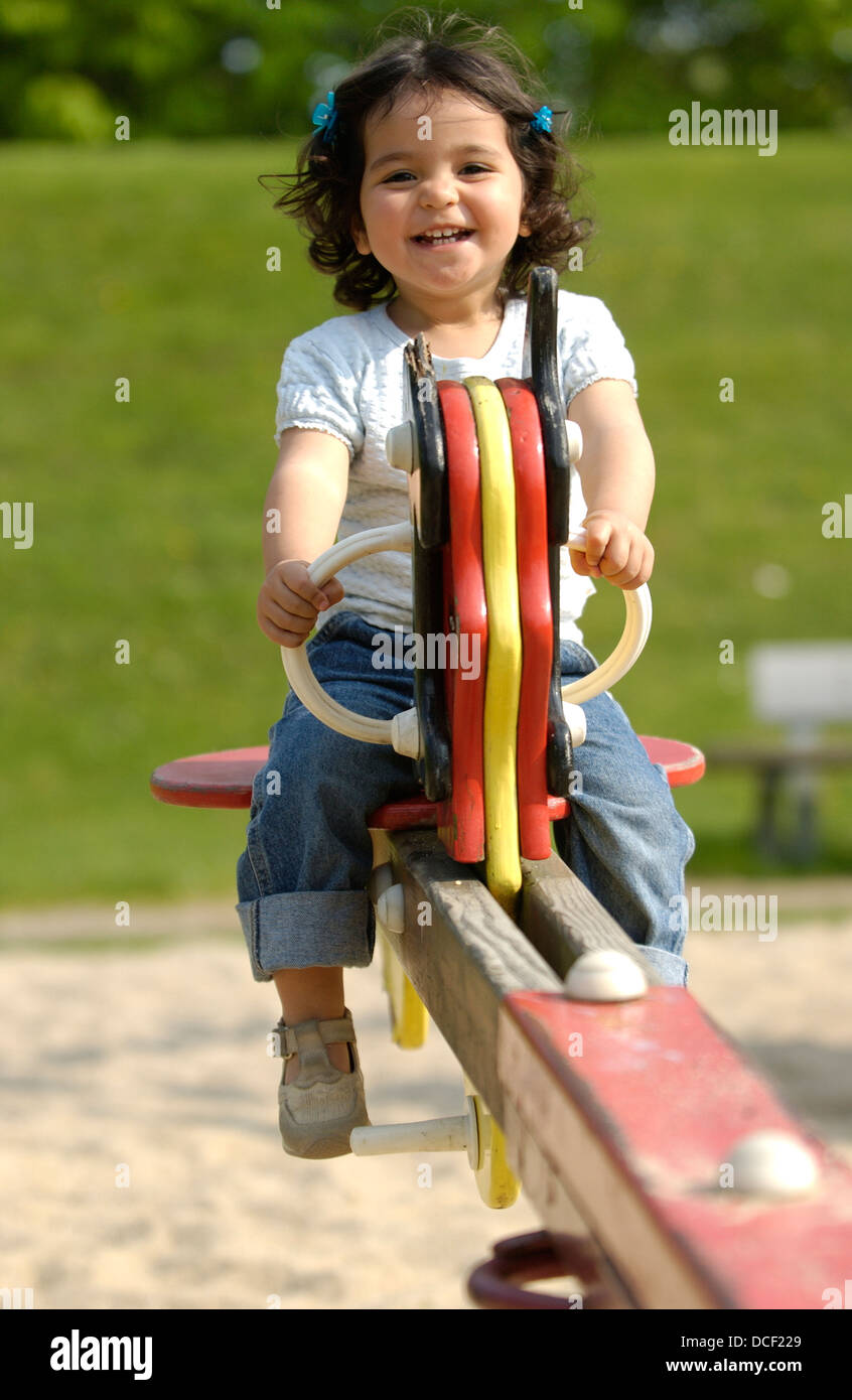 Toddler girl on a seesaw on the playground Stock Photo - Alamy