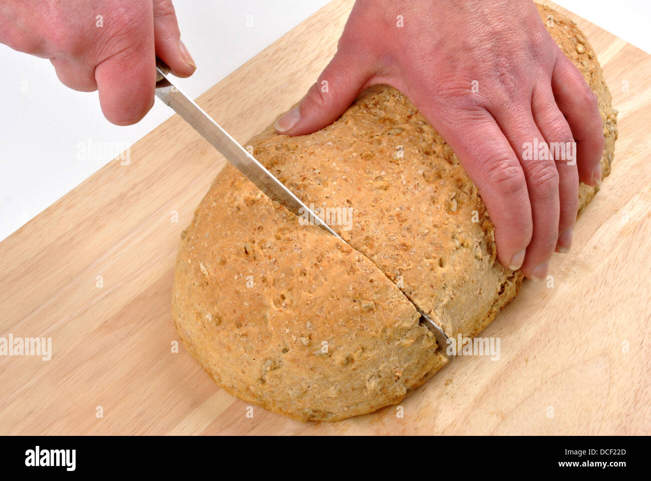 cut some organic bread at home with a knife Stock Photo - Alamy