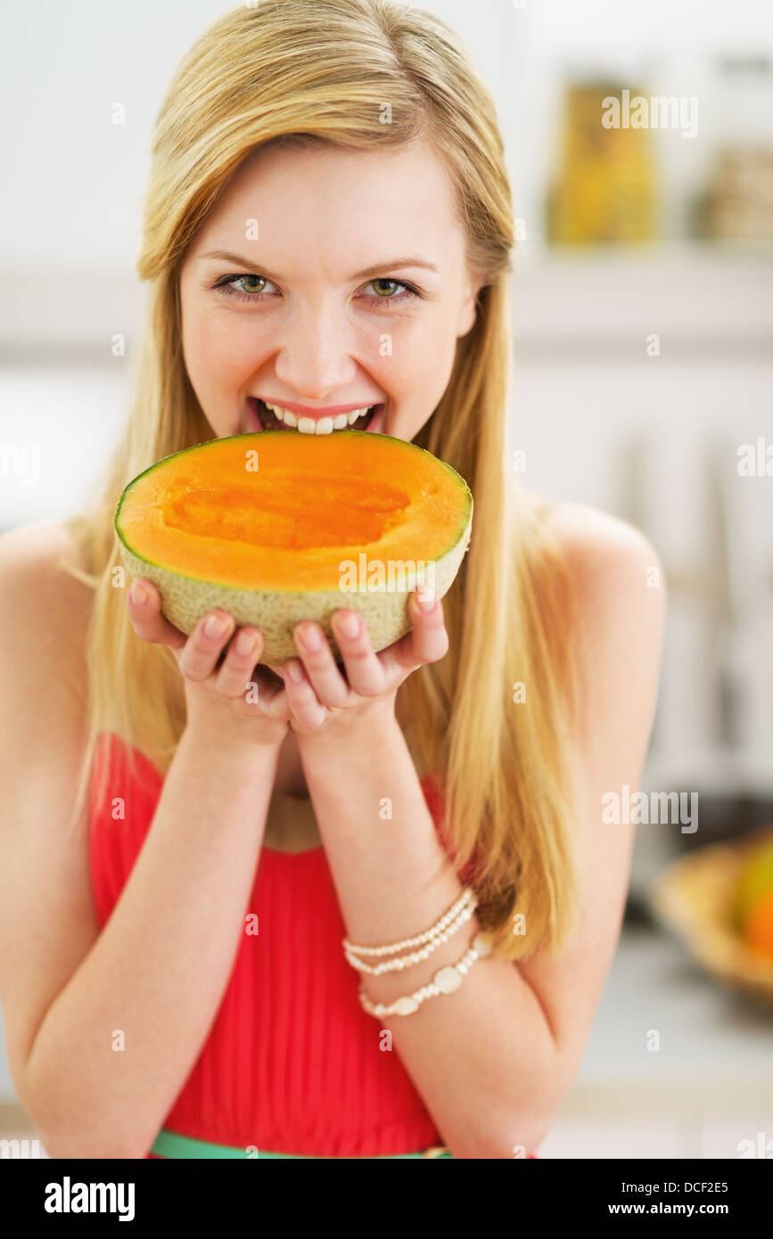 Portrait of happy young woman biting melon Stock Photo - Alamy