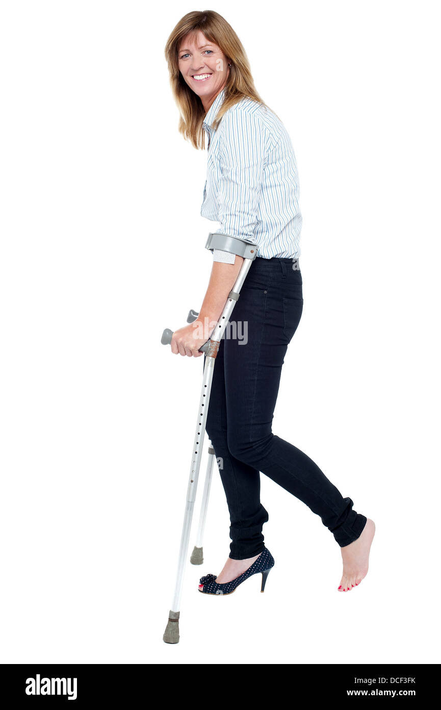 Smiling woman walking with help of crutches. Full length portrait Stock ...