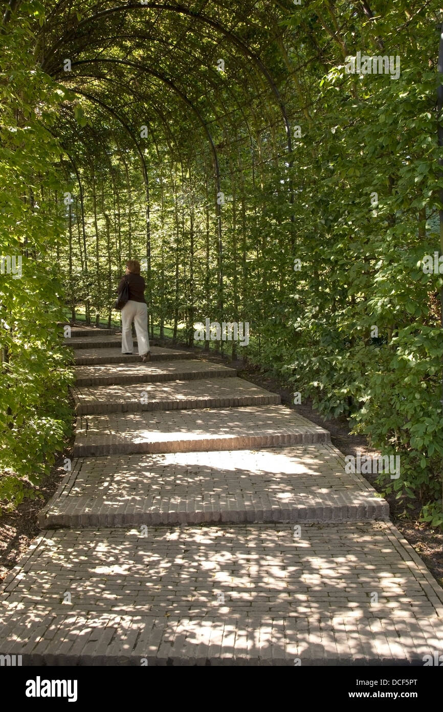 Woman Walking Down A Covered Path Stock Photo - Alamy