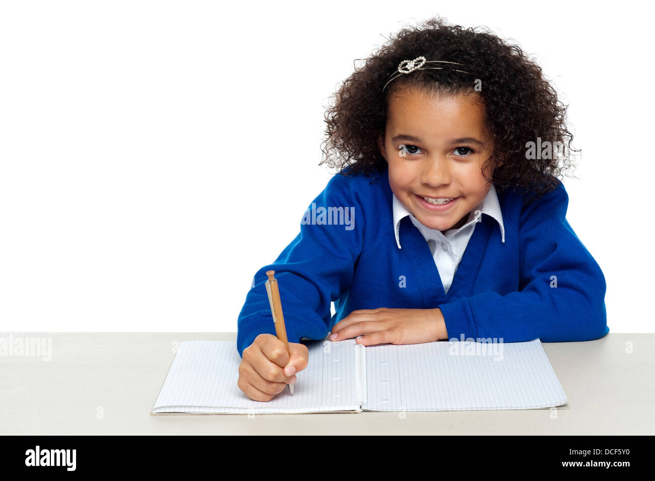 Studio shot of a cute primary kid writing her assignment Stock Photo ...