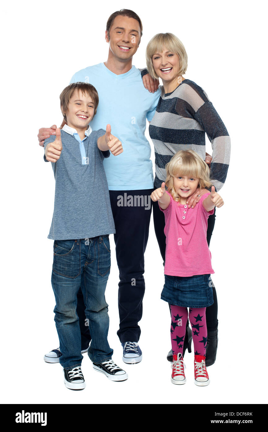 Snapshot of a successful family of four gesturing thumbs up. Strong ...