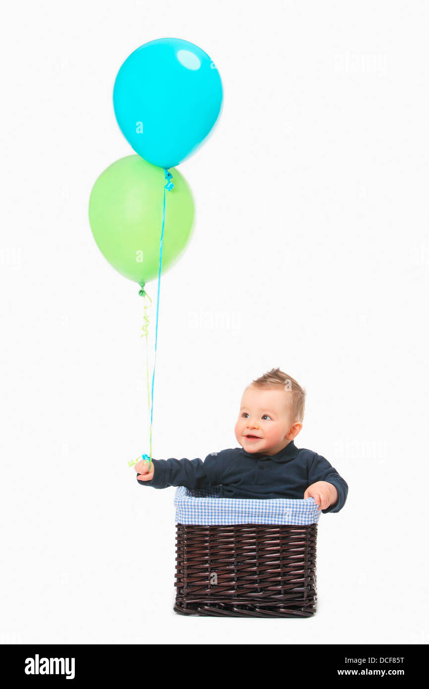 Boy In A Basket With Balloons Stock Photo - Alamy