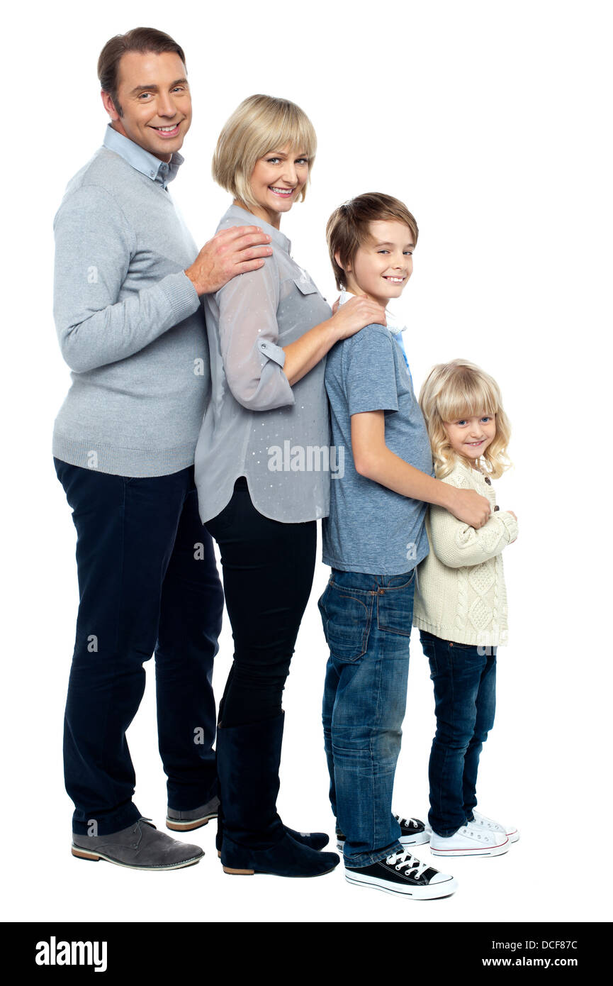 Full length family portrait of four members. Standing in a line ...