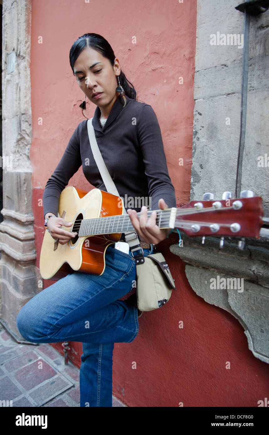 Female musician playing acoustic guitar; Guanajuato, Guanajuato, Mexico ...