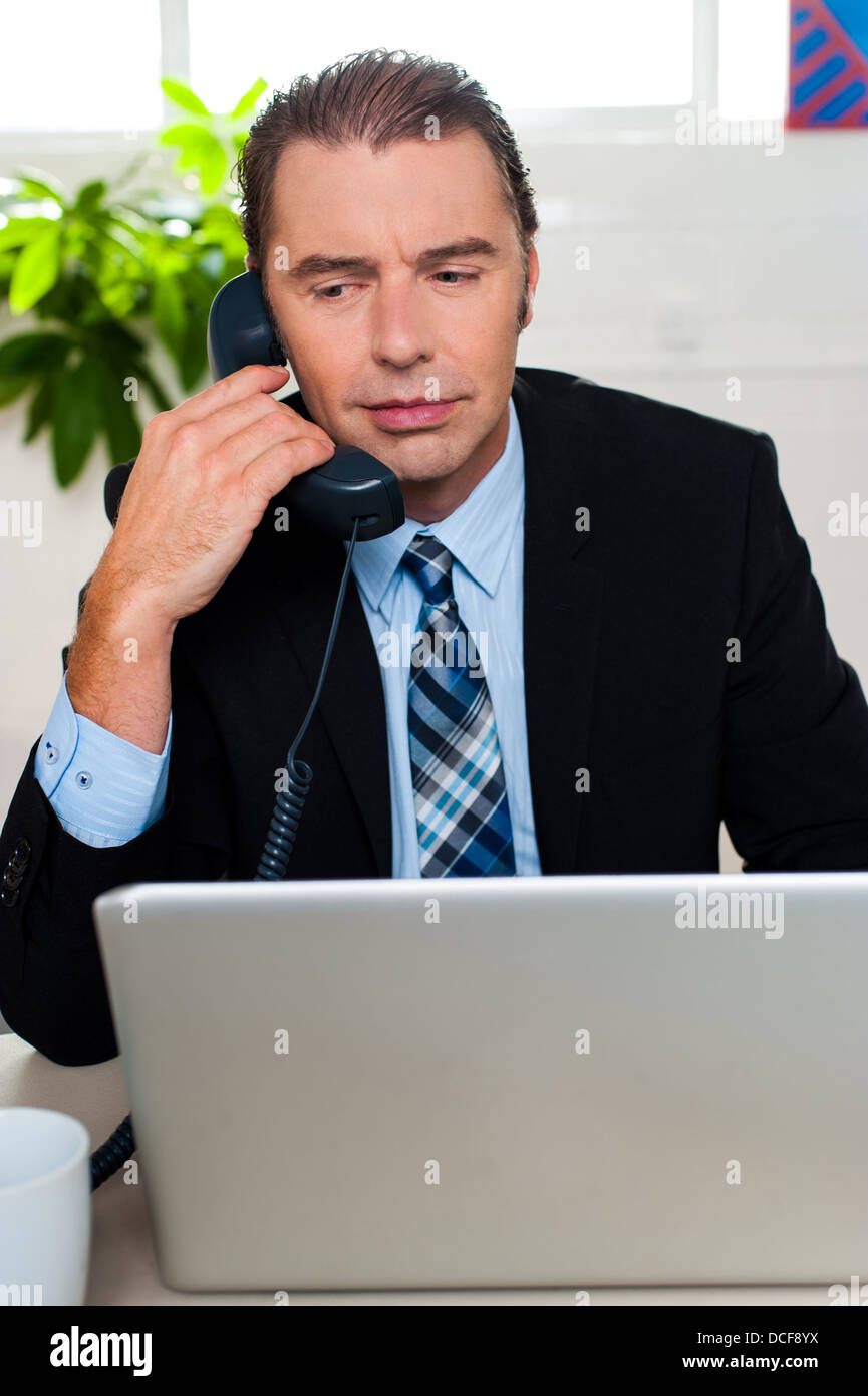 Businessman in office talking serious issue over a phone call Stock ...