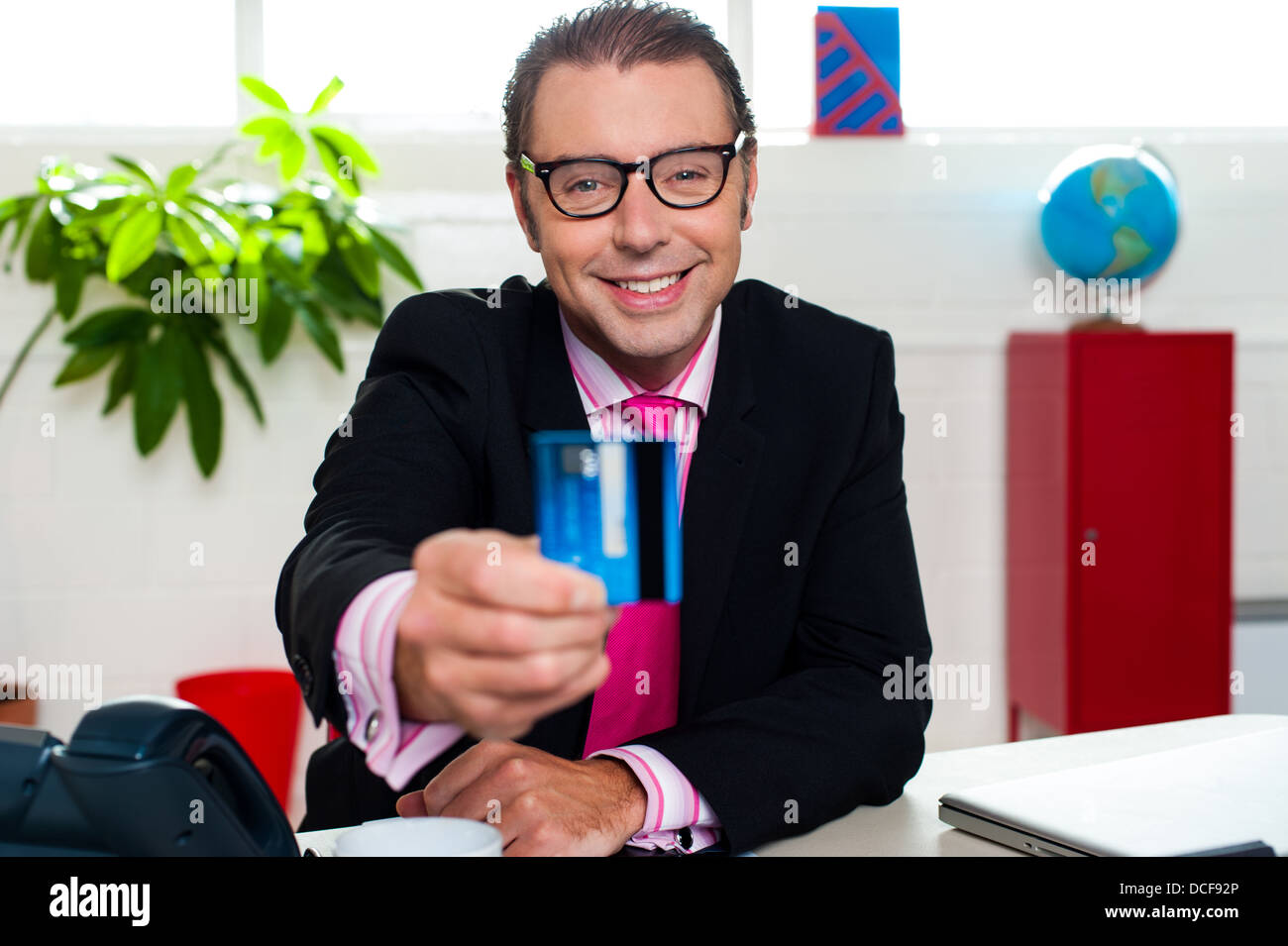 Young male executive in office offering you his credit card Stock Photo ...