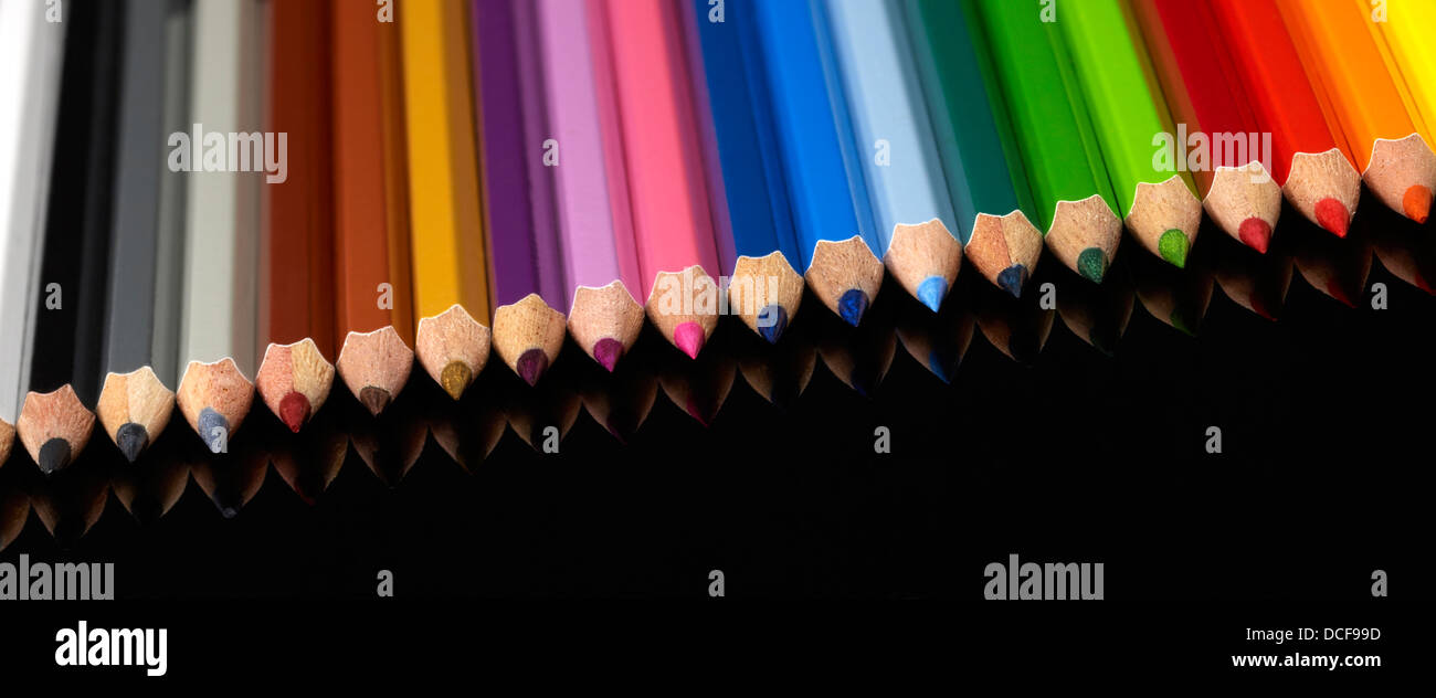 lots of colorful pencils in black reflective back Stock Photo - Alamy